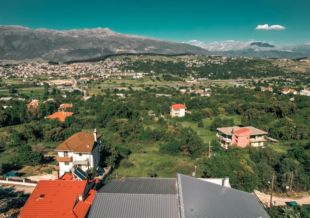 Área residencial com casas, uma cordilheira ao fundo e céu claro.