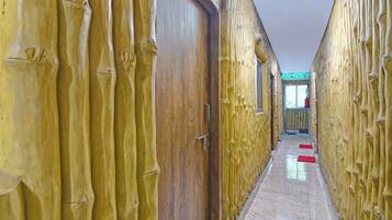 Um corredor com portas de madeira e chão de azulejos.