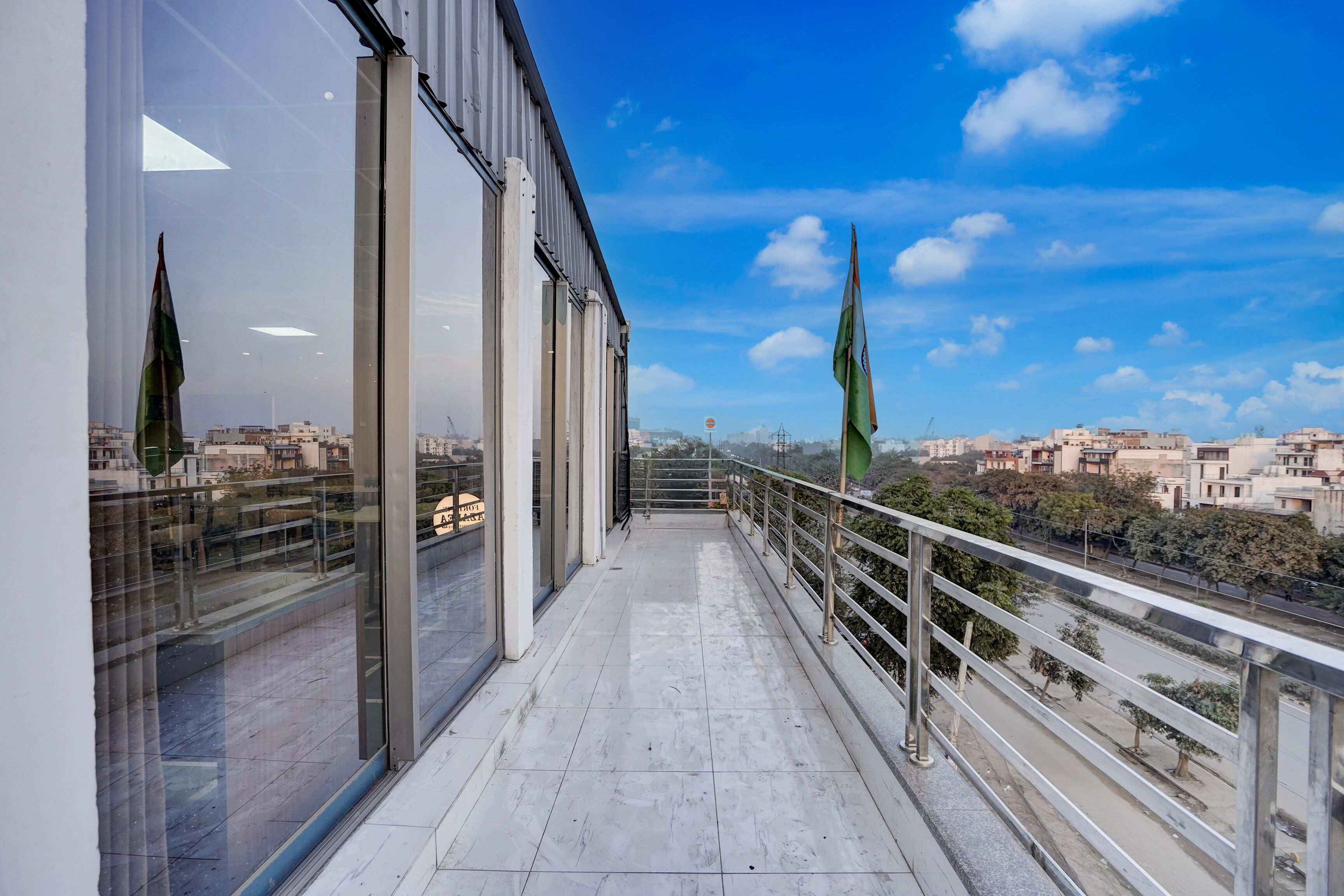 Uma varanda com vista para a paisagem urbana, incluindo edifícios e uma bandeira.