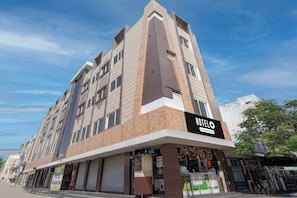 Um edifício de vários andares com uma placa indicando 'HOTELO' e 'Company Serviced' no andar térreo.