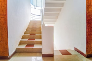 Uma escada com corrimão, conduzindo a um andar superior.