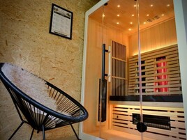 Um quarto com uma cadeira preta, uma parede de ripas de madeira e um aviso emoldurado na parede.