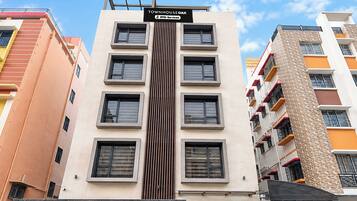 Um edifício de vários andares com uma placa que diz 'TOWNHOUSE OAK' e 'Oyo-Service'.