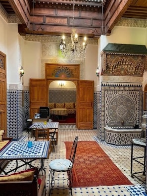 Um interior com área de refeições, parede estampada e teto decorativo.