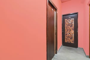 Um corredor com porta de madeira e parede revestida de azulejos.