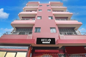 Edifício de hotel com vários andares e um letreiro grande com a palavra 'HOTEL' na fachada.