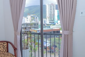 Uma varanda com vista para o horizonte urbano, incluindo edifícios e uma colina.