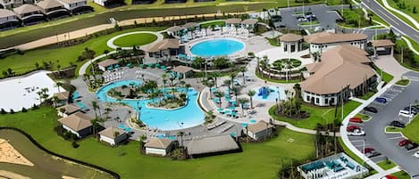 Vista aérea de uma área residencial com várias piscinas, um campo de golfe e um estacionamento.