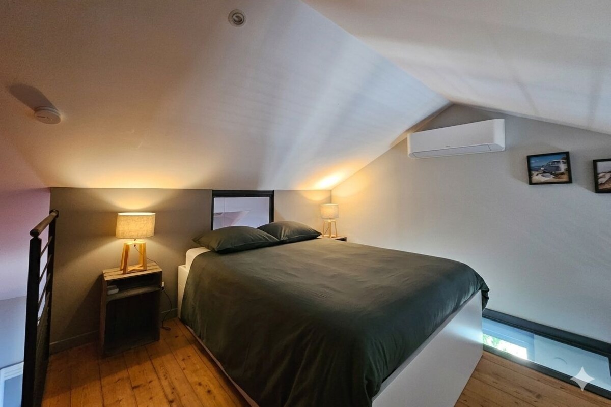 Quarto com cama, abajures, ar-condicionado na parede e janela.