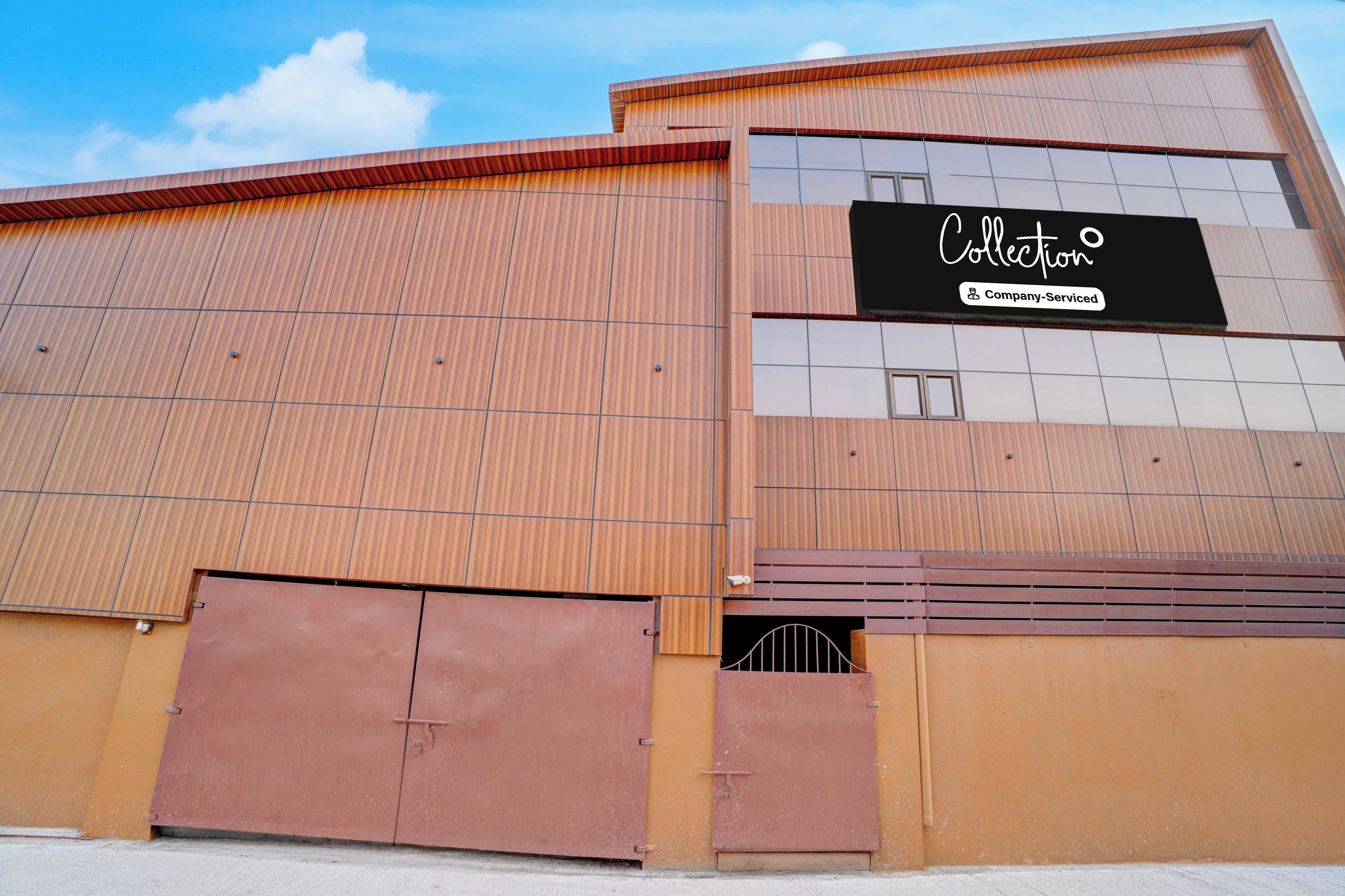Um grande edifício industrial com uma placa que diz 'Collection Company-Serviced'.