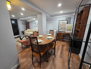 Uma área de refeições com mesa de madeira, cadeiras e um aparador para buffet.