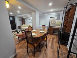 Uma área de refeições com mesa de madeira, cadeiras e um aparador para buffet.
