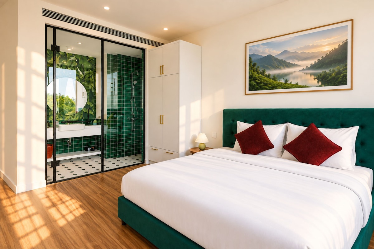 Quarto com uma cama grande, cabeceira verde e um quadro de uma paisagem na parede.