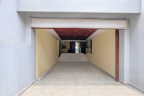 Um corredor com piso estampado que leva a uma escadaria.