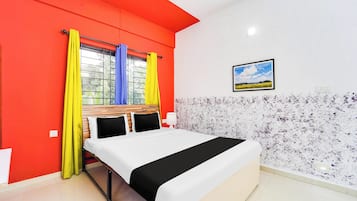 Quarto com cama, cortinas, janela com vista, um quadro na parede e um interruptor de luz.