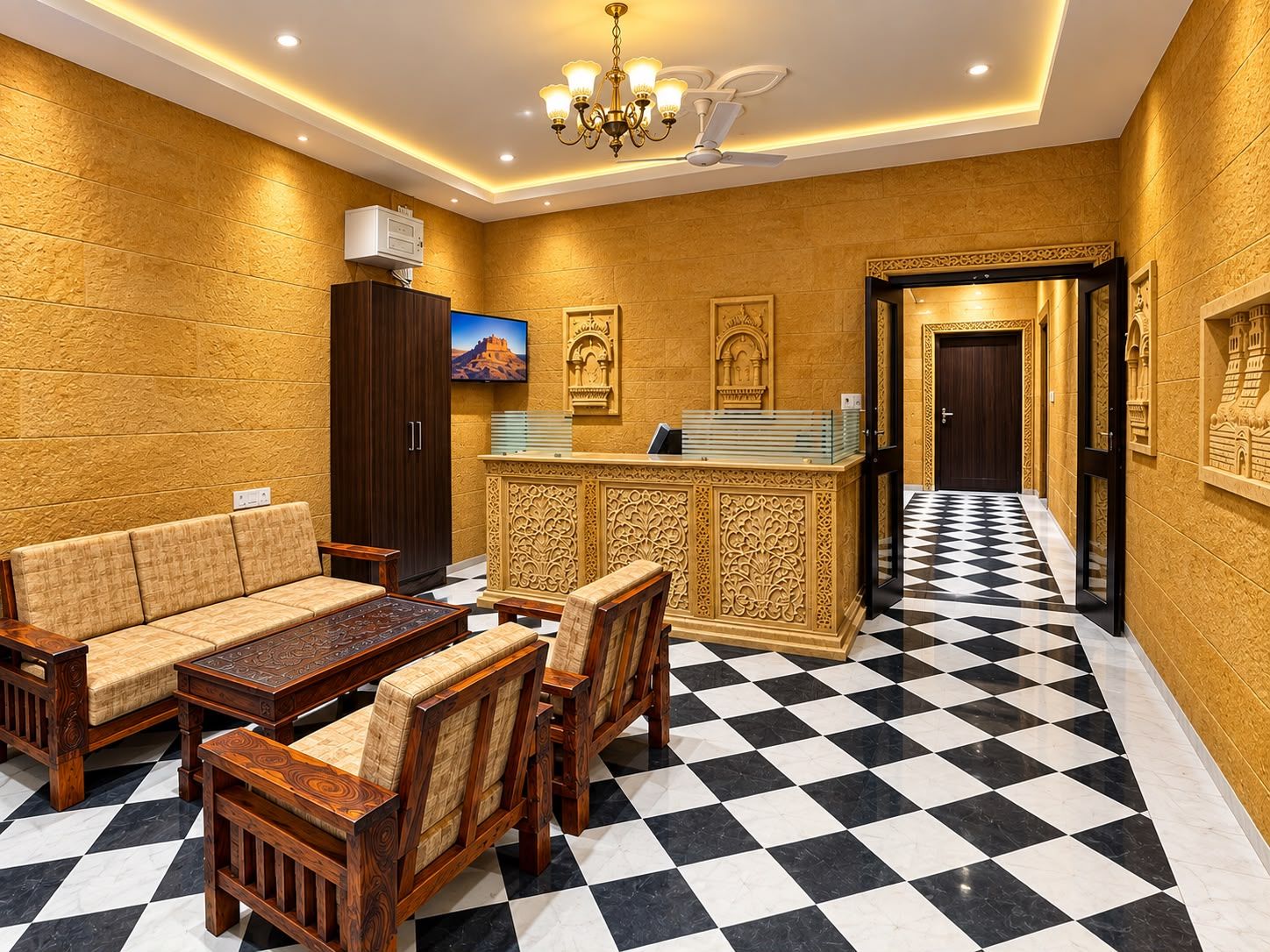 Um saguão de hotel com balcão de check-in, área de estar e mesa de recepção.
