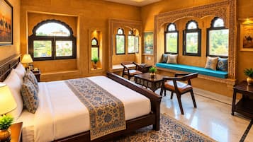 Quarto com uma cama grande, área de estar com sofá e poltronas, uma mesinha e elementos decorativos.