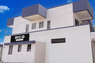 Um edifício de hotel moderno com uma placa que diz 'HOTELO Company-Serviced'.