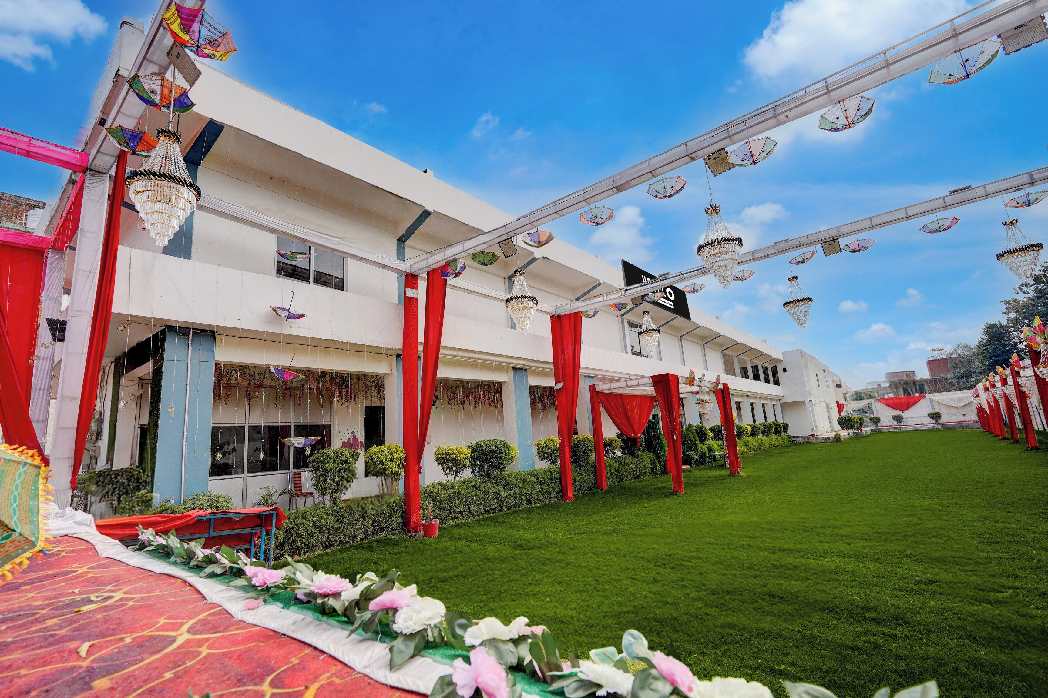 Um edifício com fachada branca, cortinas vermelhas e decorações penduradas.