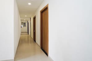 Um corredor com portas de madeira e chão de azulejos.