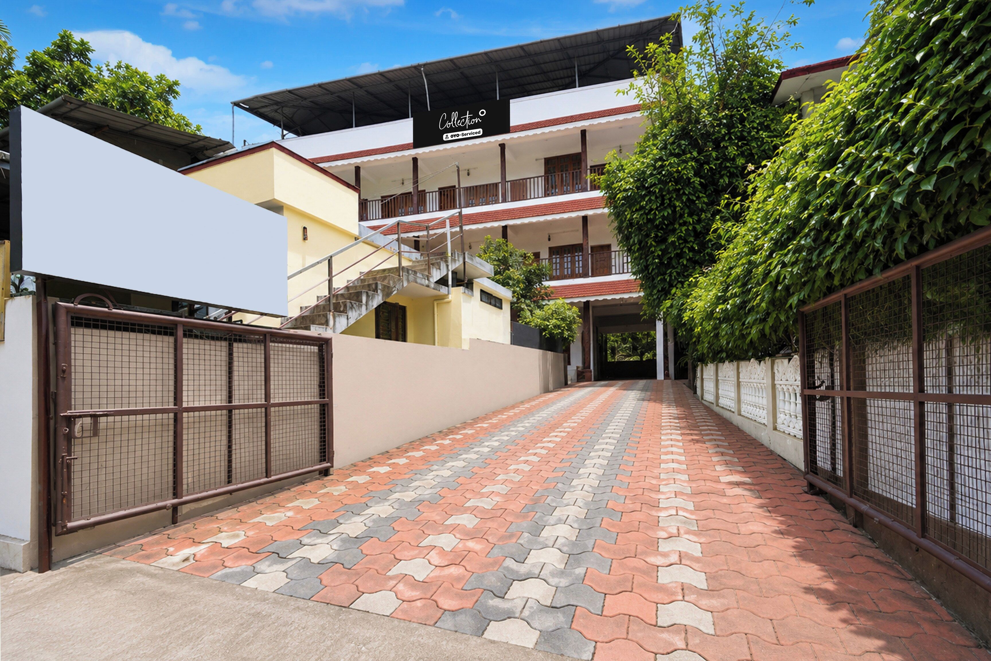 Um edifício com galeria coberta, portão e escadaria que dá acesso a um segundo andar.