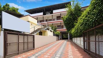 Um edifício com galeria coberta, portão e escadaria que dá acesso a um segundo andar.