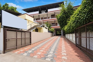 Um edifício com galeria coberta, portão e escadaria que dá acesso a um segundo andar.
