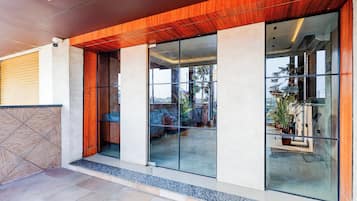 Um edifício moderno com grandes portas de vidro, teto de madeira e chão ladrilhado.