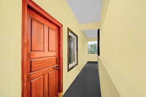 Um corredor com uma porta de madeira e uma janela.