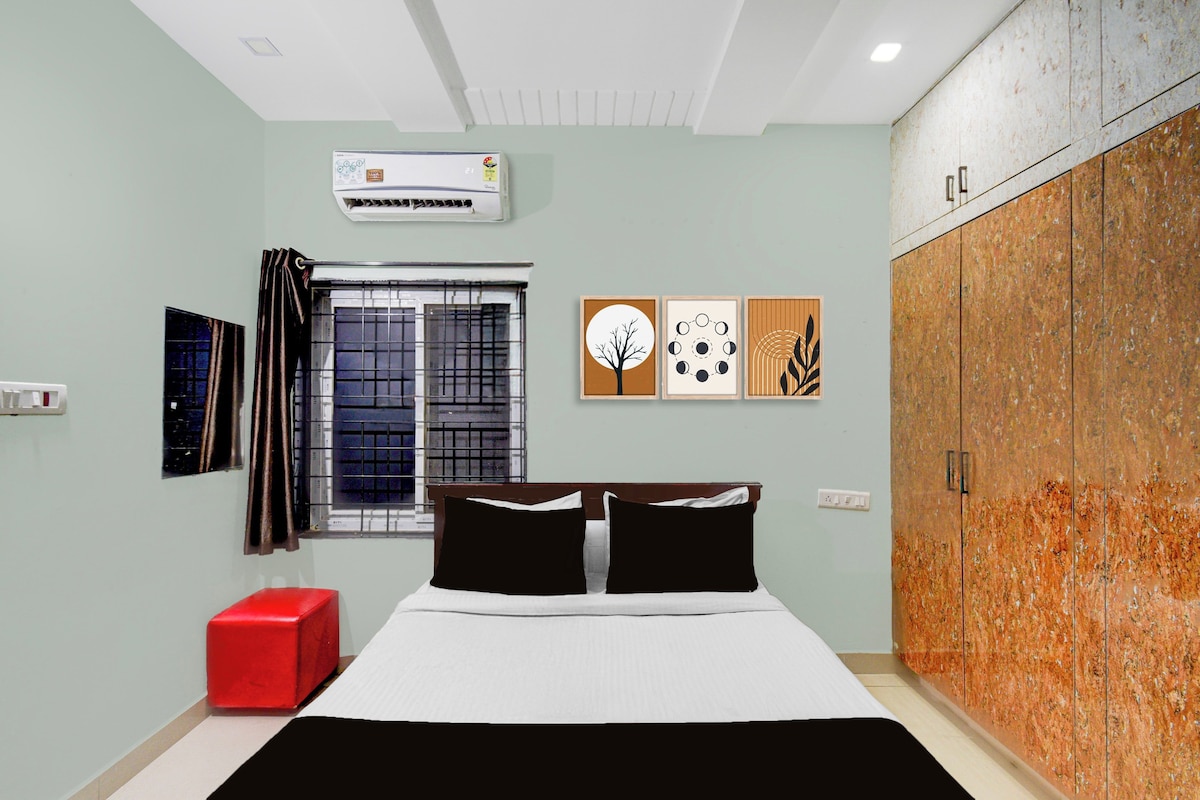 Quarto com cama, guarda-roupa, ar condicionado, janela com cortinas e decoração nas paredes.