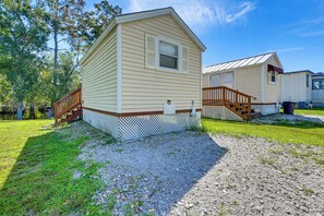 Casa móvel com um deck de madeira e um pequeno alpendre.