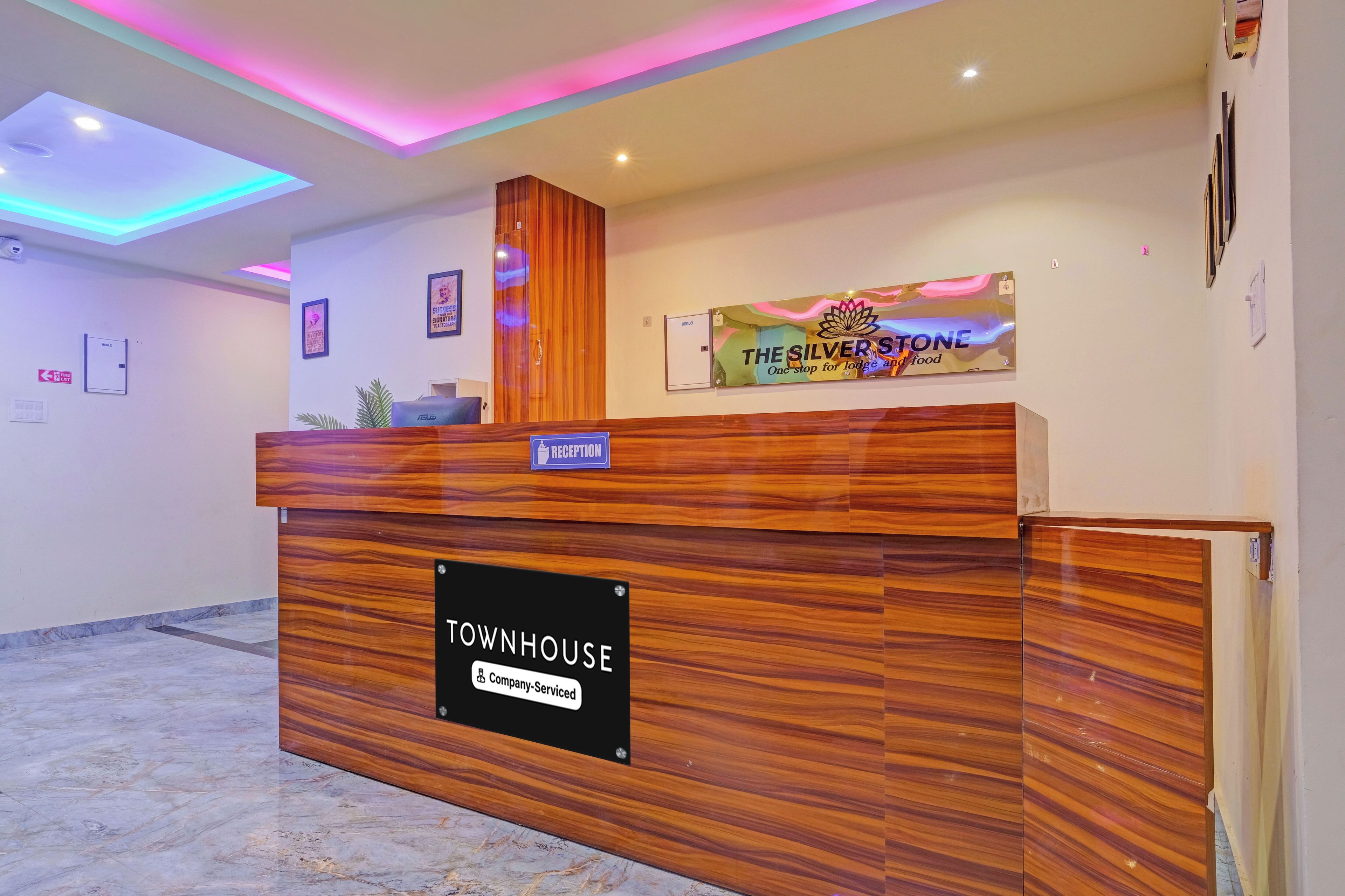 Bancada de recepção com placa indicando 'Reception' e 'Townhouse', com a etiqueta 'Company-Serviced'.