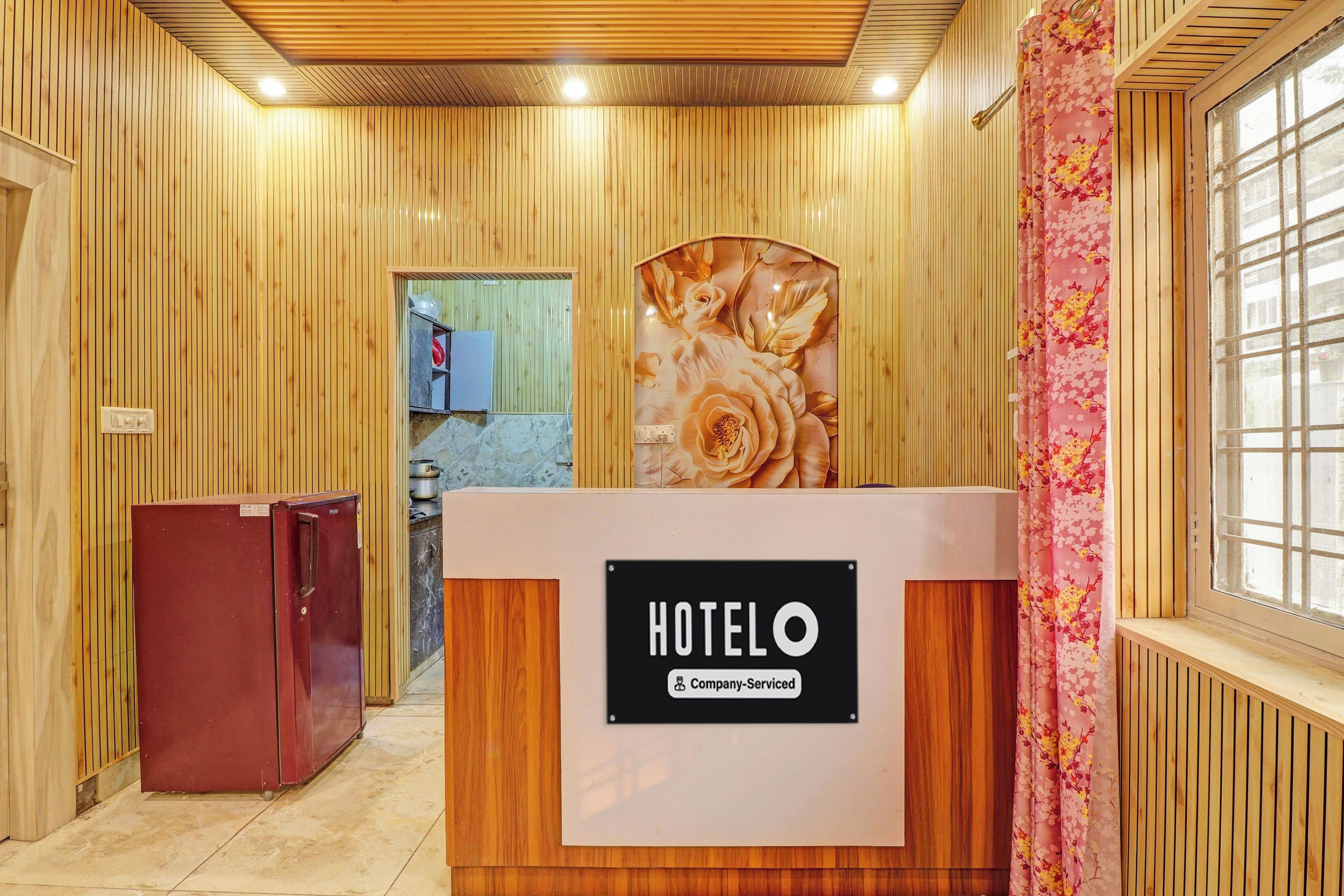 Balcão de recepção de hotel com uma placa que diz 'HOTELO Company Serviced'.