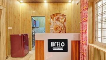 Balcão de recepção de hotel com uma placa que diz 'HOTELO Company Serviced'.