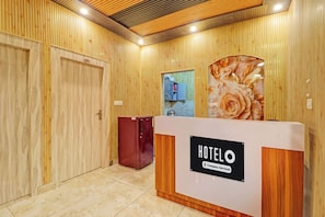Balcão de recepção de hotel com aviso indicando serviço da empresa.