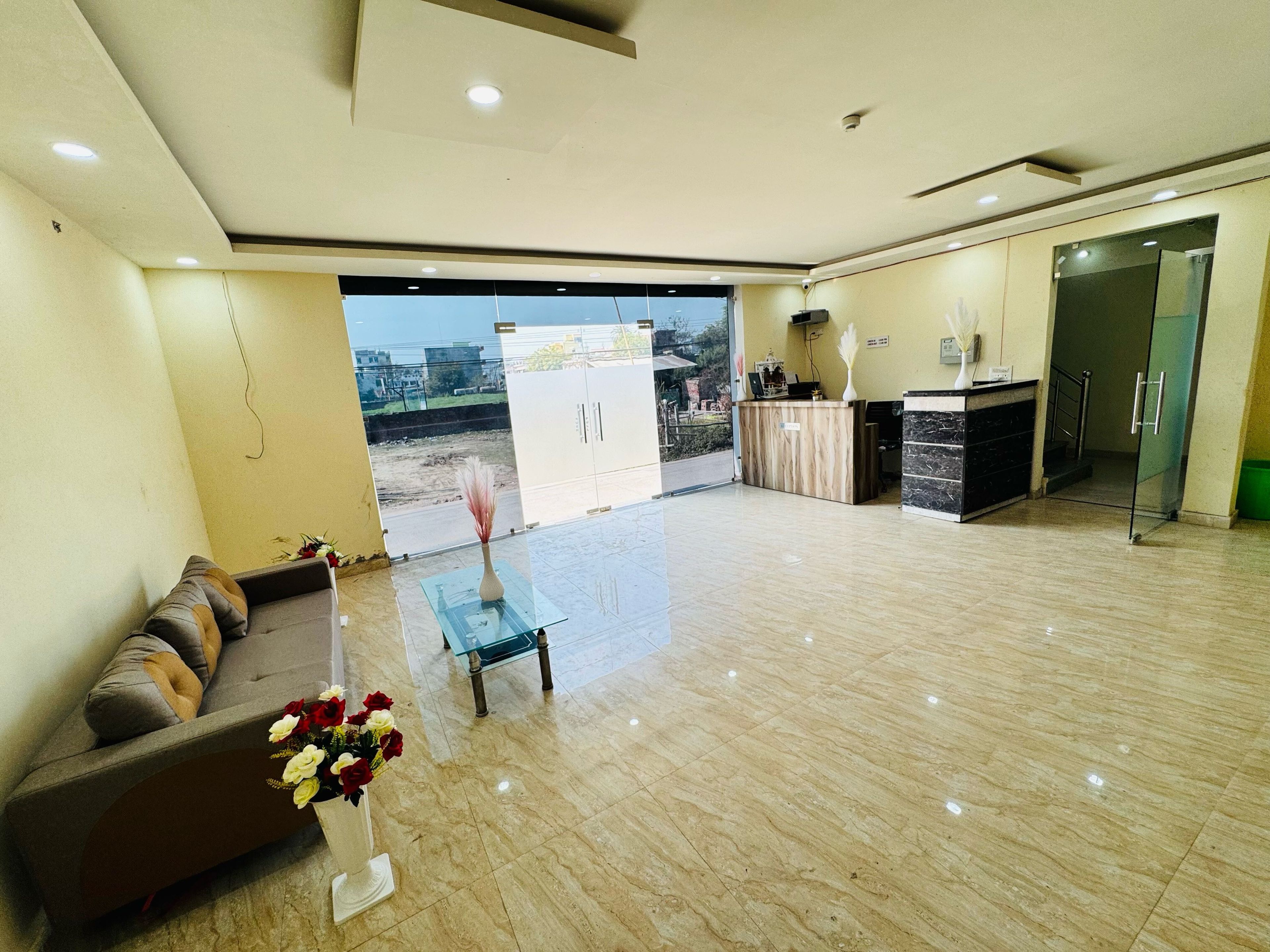 Um hall amplo com balcão de recepção, sofá e mesinha de centro.