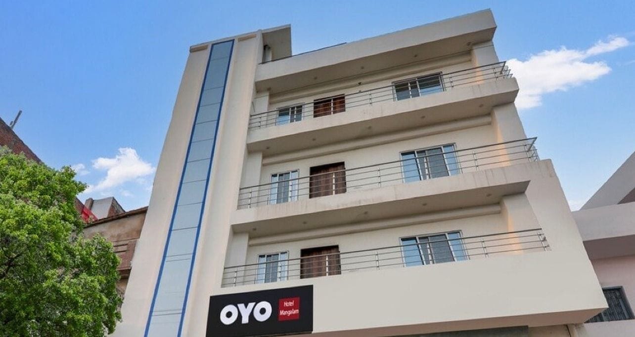 Um edifício de hotel com vários andares, com uma placa indicando ser o OYO Hotel Mangilan.
