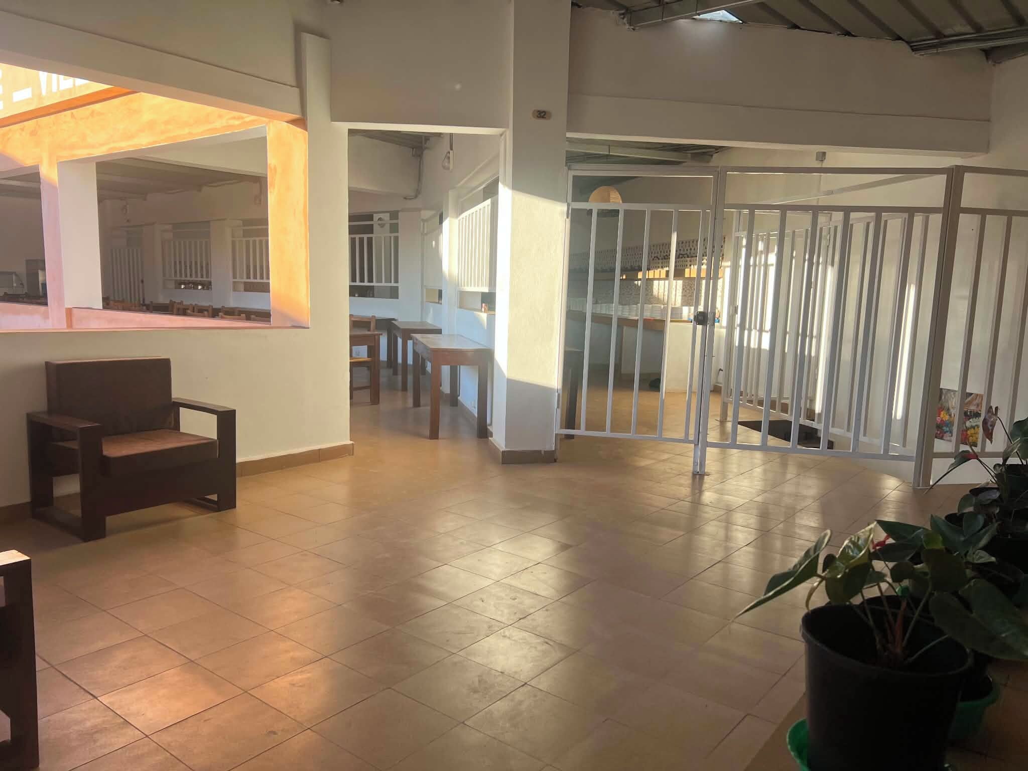 Amplo espaço interno com área de estar, balcão e vista para outro ambiente.