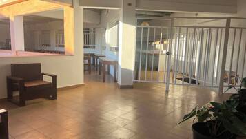 Amplo espaço interno com área de estar, balcão e vista para outro ambiente.