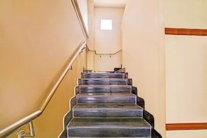 Escadaria com corrimão de metal e luminária no topo.