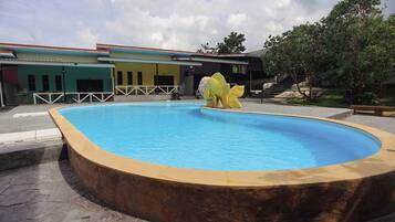 Piscina com borda curva e revestimento de pedra.