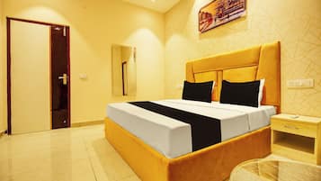 Quarto de hotel com cama, mesa de cabeceira e uma obra de arte na parede.