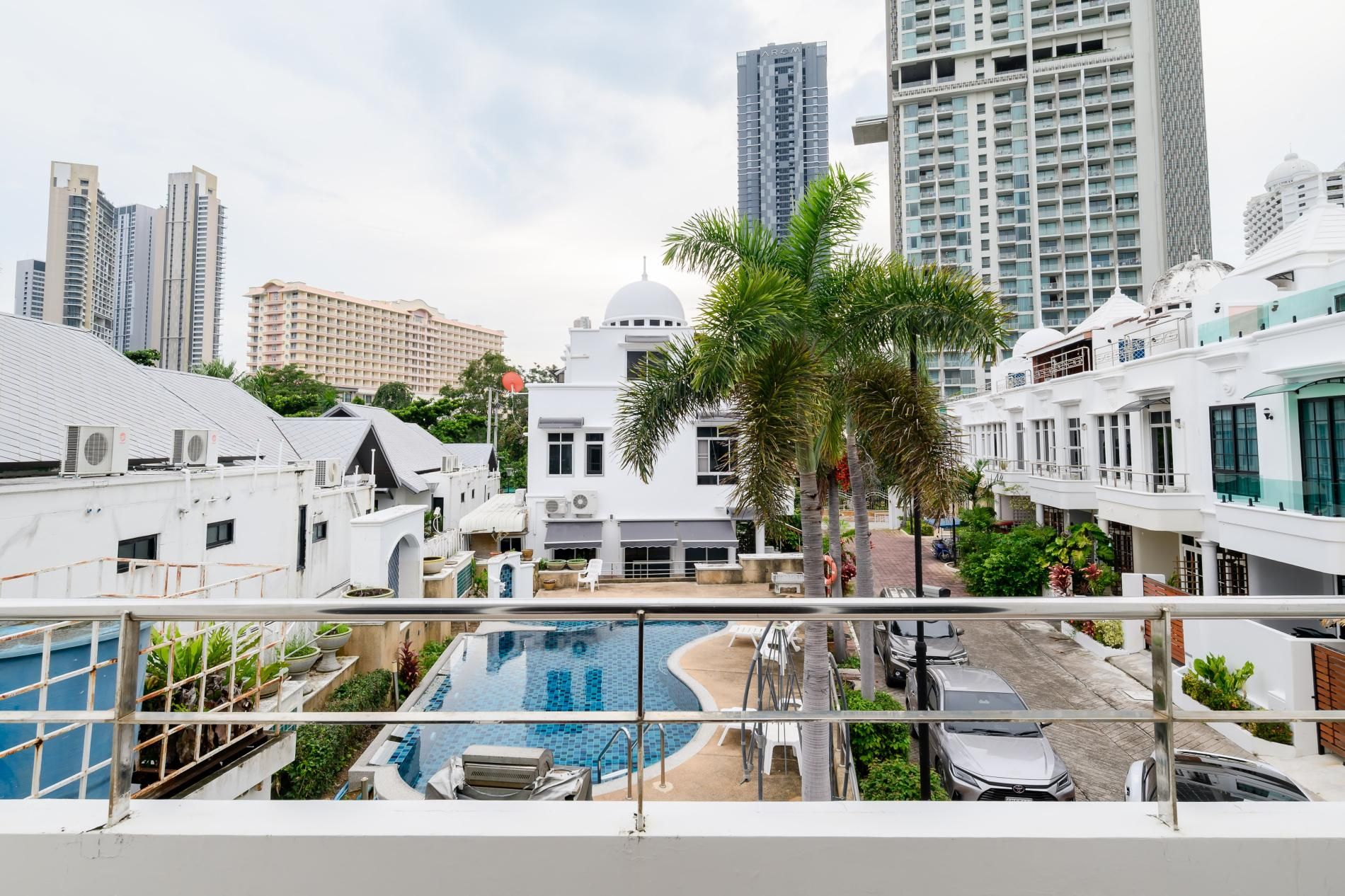 Piscina no terraço com vista para edifícios ao redor, incluindo um hotel e arranha-céus.