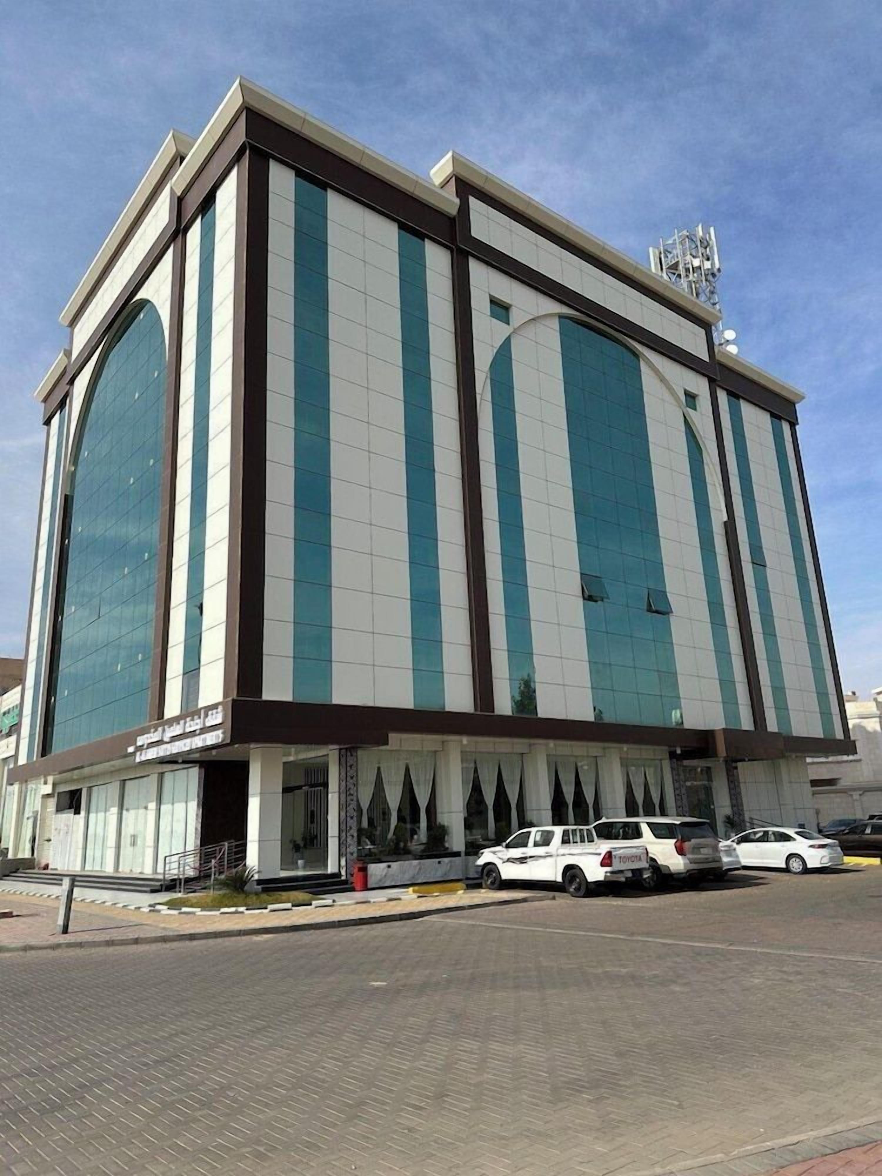 Edifício moderno de vários andares, com design arquitetônico marcante, fachada em vidro e uma série de janelas verticais.