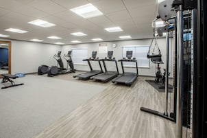 Sala de ginástica com esteiras, elípticos e remo.