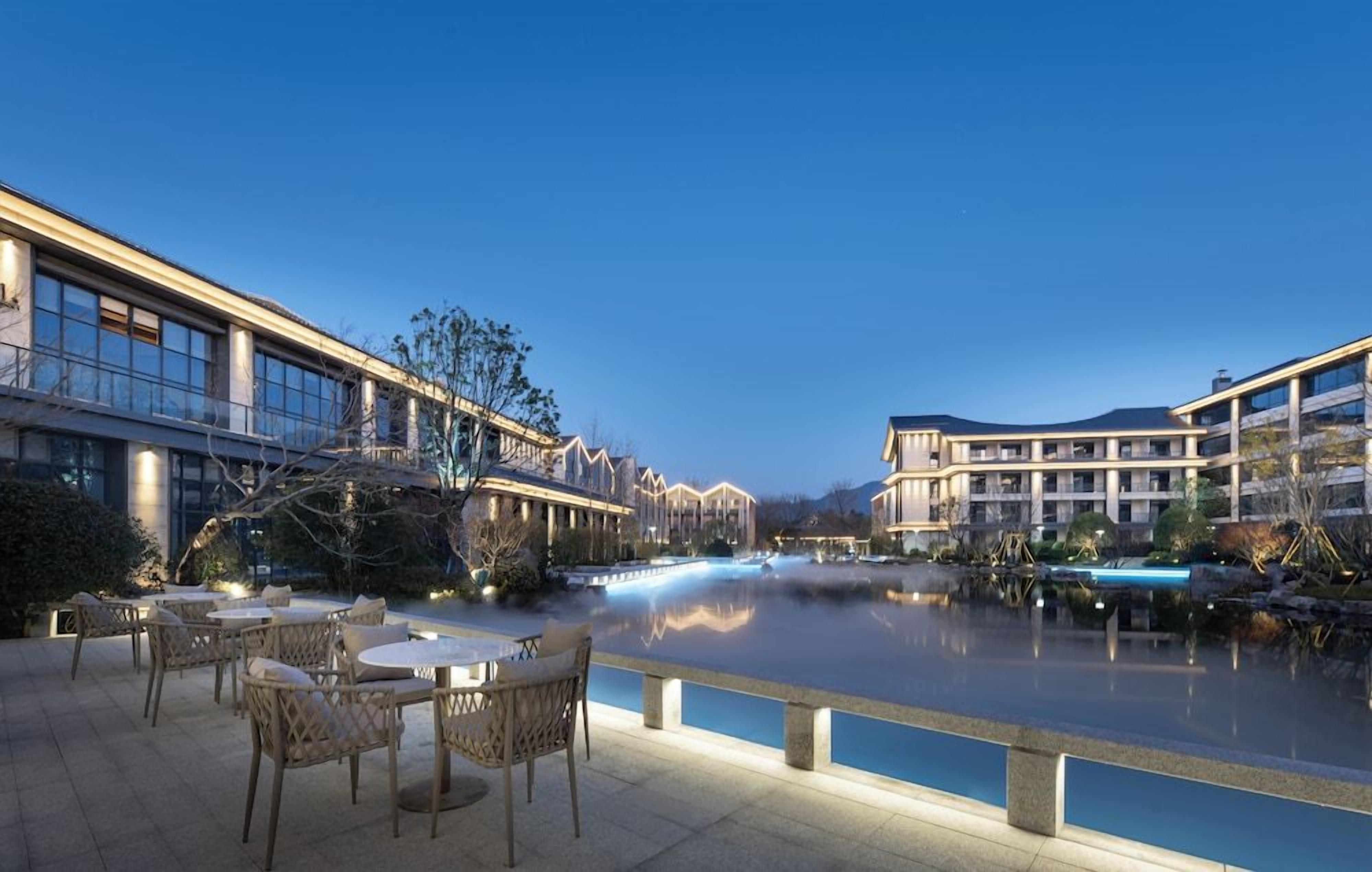 Hotel à beira do rio com área de estar ao ar livre e piscina refletora.