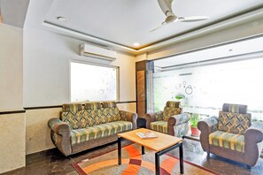 Uma área de estar moderna com sofás, uma mesa de centro e um ventilador de teto.