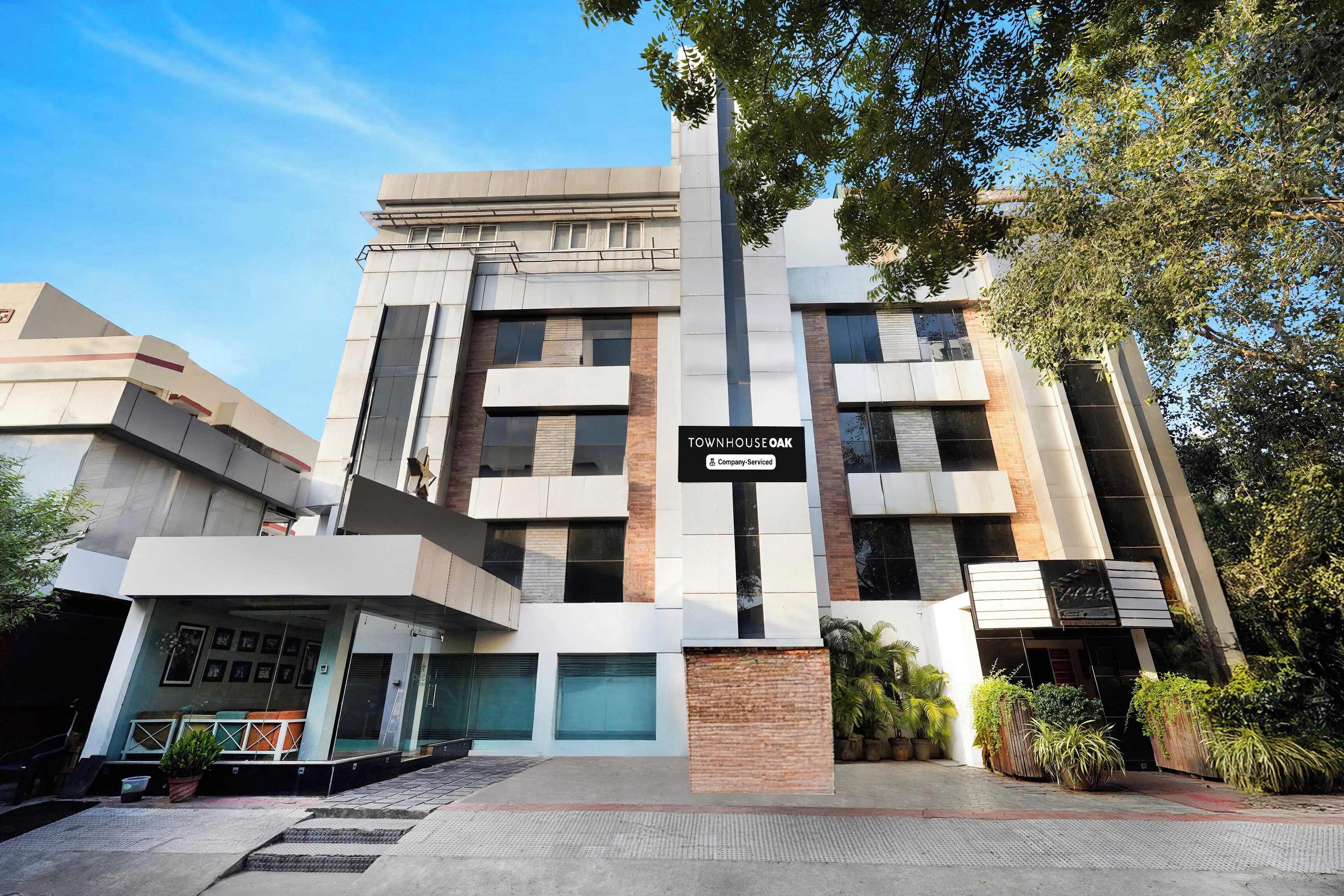 Um edifício moderno com uma placa indicando 'Company Serviced' e uma entrada visível.