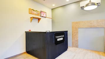 Bancada de recepção com placa indicando 'TOWNHOUSE Company Serviced'.