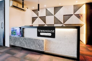 Bancada de recepção com placa indicando 'TOWNHOUSE Company Serviced'.